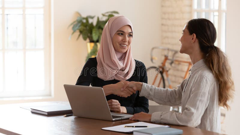 Middle Eastern Ethnicity and Mixed-race Businesswomen Shaking Hands ...