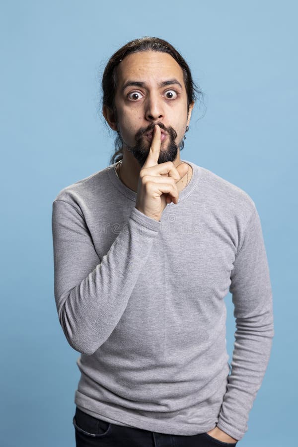 Middle Eastern Guy Expressing Hush and Be Quiet Symbol with Finger Over ...