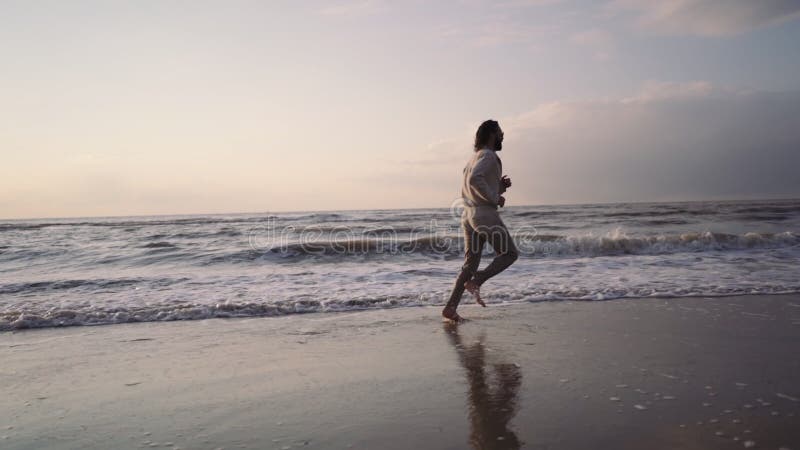 Middle Eastern Man Running on the Shore of an Ocean during Sunset Stock ...