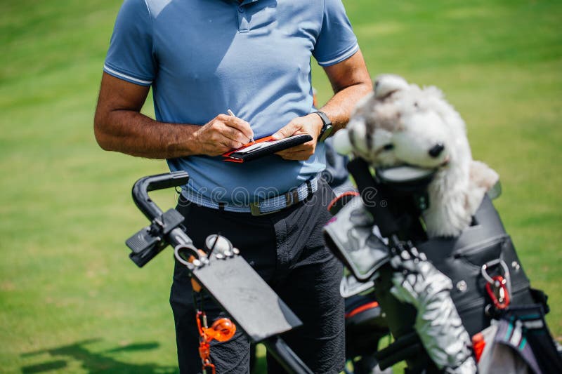 Midsection of Golfer Writing on Score Card Standing at Golf Course ...