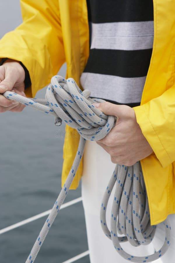 Midsection of Man Tying Rope on Sailboat Stock Image - Image of ...