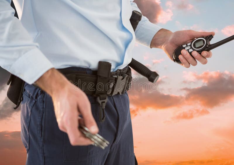 Midsection of Security Guard Holding Roadio Against Sky during Sunset ...