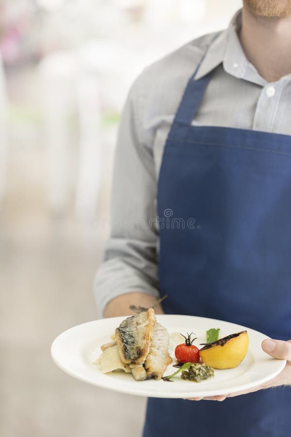 Young Waiter Showing Menu To Mature Couple at Restaurant Stock Image ...