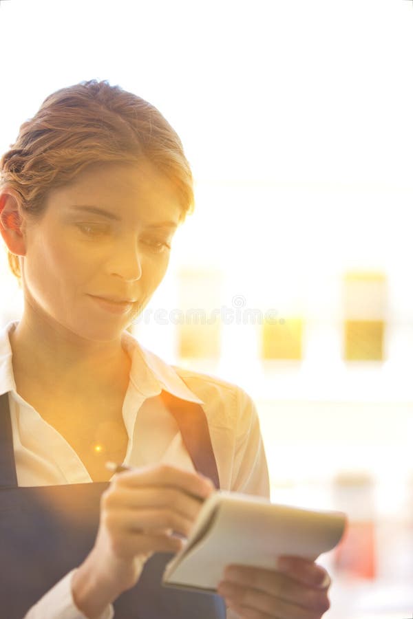 Midsection of Young Waitress Writing on Notepad at Restaurant Stock ...