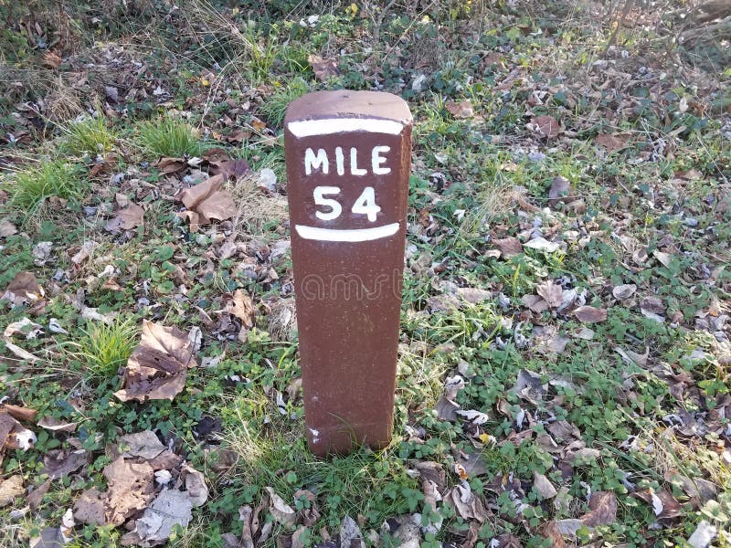 Two Mile Marker Sign on Wood Post with Asphalt Trail and Brown Leaves ...