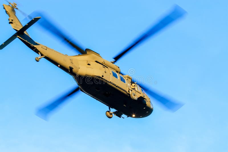 Military Helicopter Flying Against a Clear Blue Sky during a Training ...