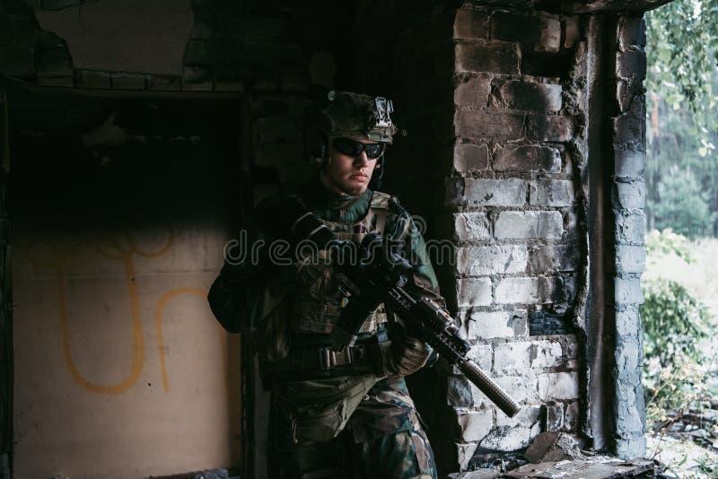 Military Man with Assault Rifle Standing Inside Building, he is Ready ...