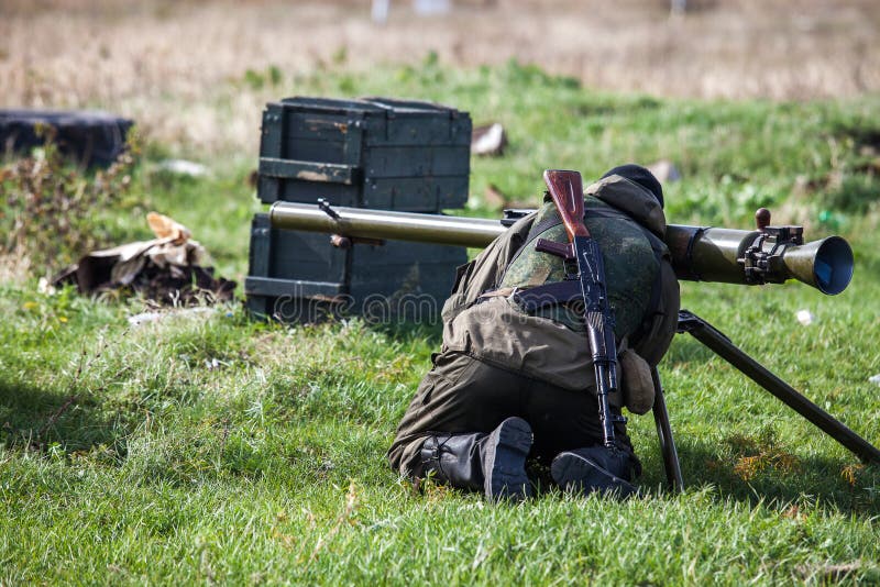 A Military Man with an Automatic Rifle on His Back Shoots from a Rocket ...
