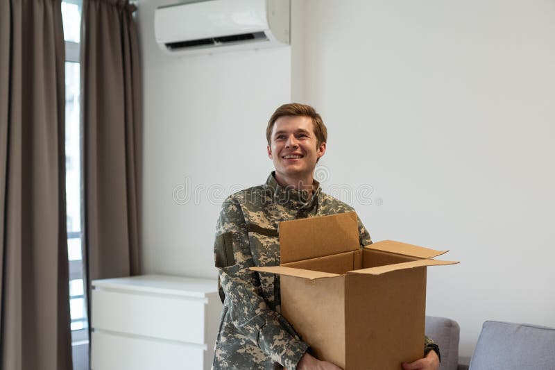 Military man holding a box stock image. Image of goods - 296510759