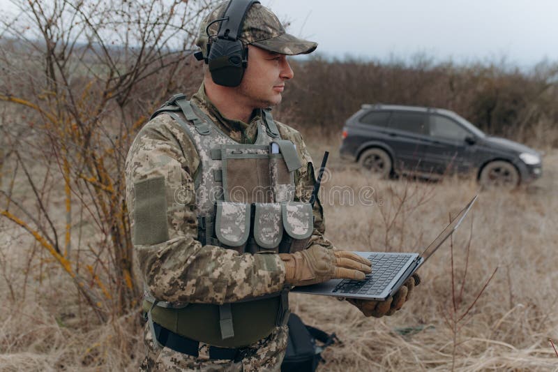 Military Man Stands in Camouflage and Works with a Laptop. Military ...
