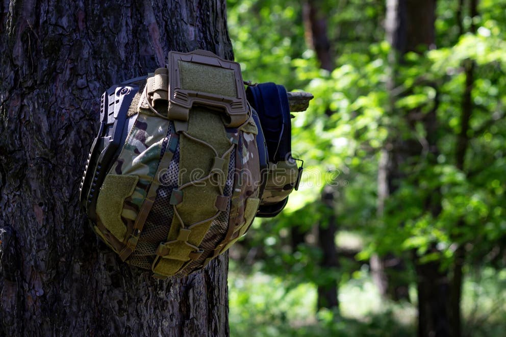 Military Tactical Helmet with a Camouflage Pattern Hangs from a Tree ...