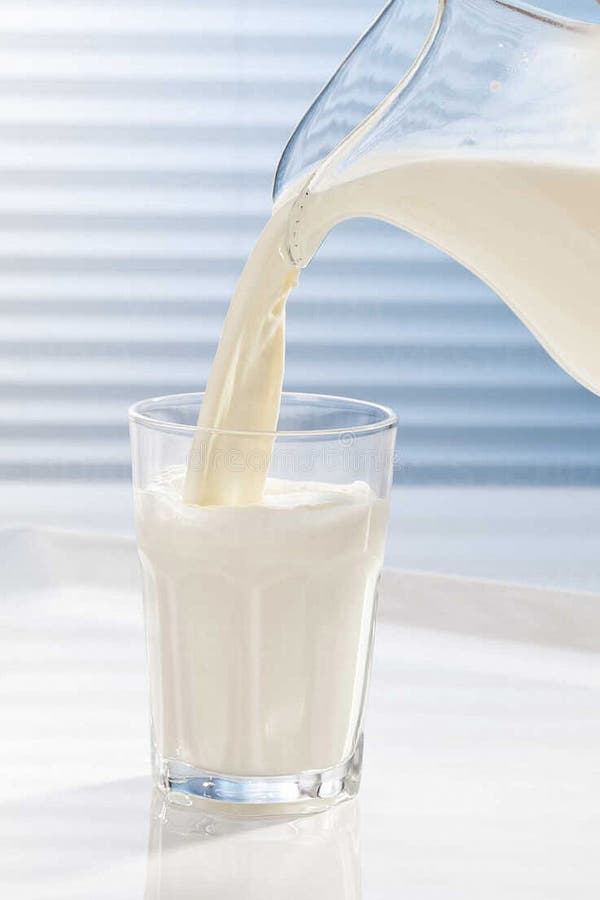 Milk Being Poured into Glass Against White Background Stock Image ...