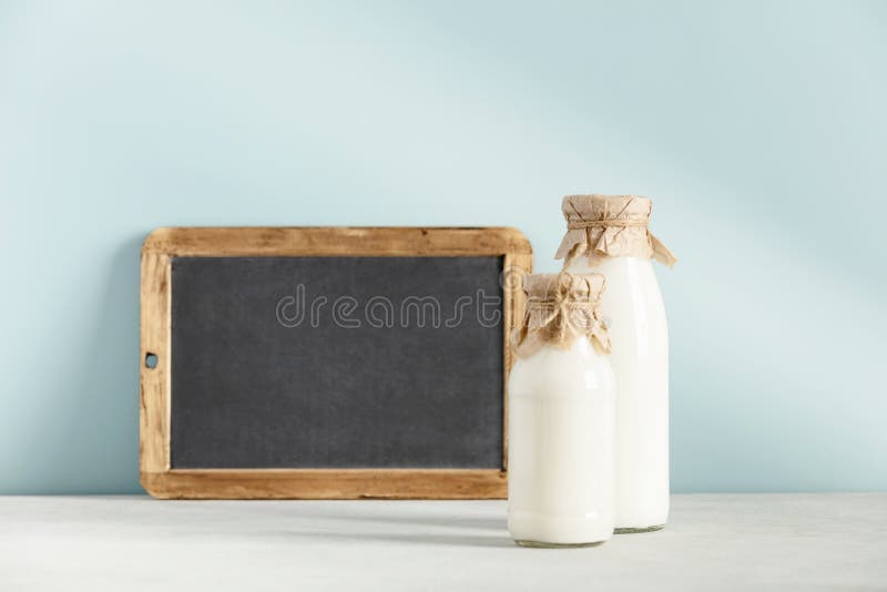 Milk in Bottles and Chalkboard on Light Blue Background Stock Photo ...