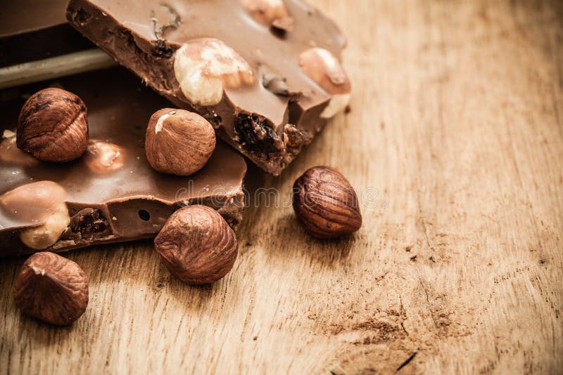 Milk Chocolate and Hazelnuts on Wooden Table Stock Photo - Image of ...