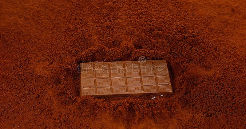 Milk Chocolate Tablet Falling on Black Chocolate Powder Stock Photo ...