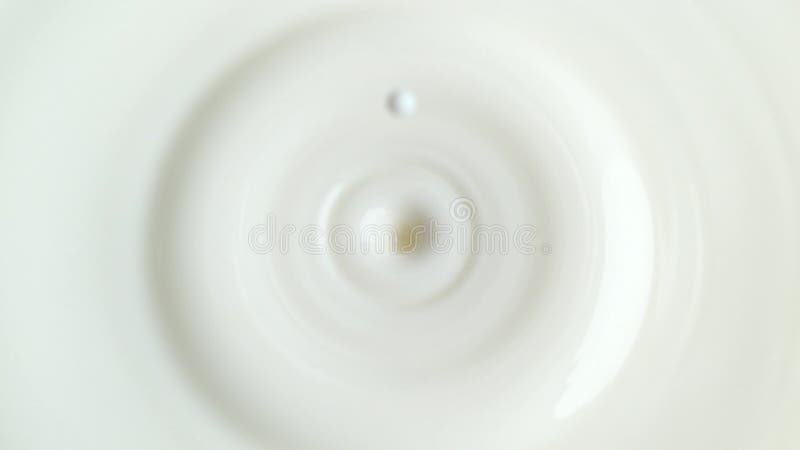 Milk Drop Dripping Onto the White Liquid Surface Making Crown and ...