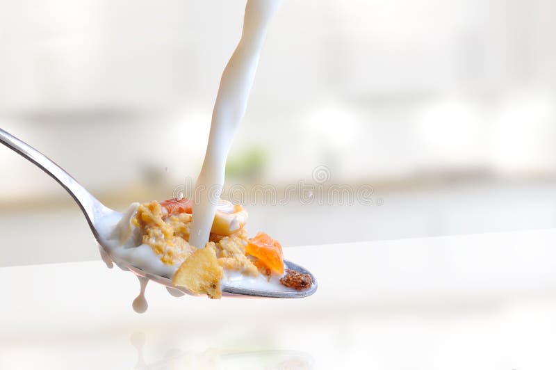 Milk Falling on a Spoon Full of Cereals in Kitchen Stock Photo - Image ...