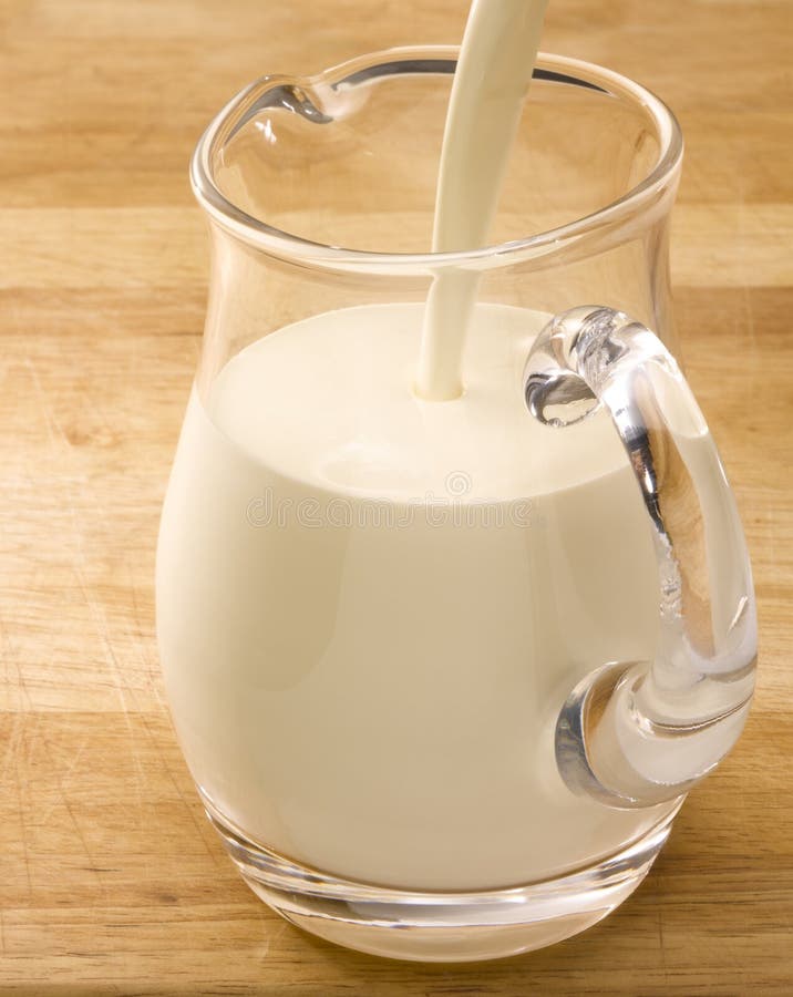 Milk jug on wooden table stock photo. Image of liter - 21432586