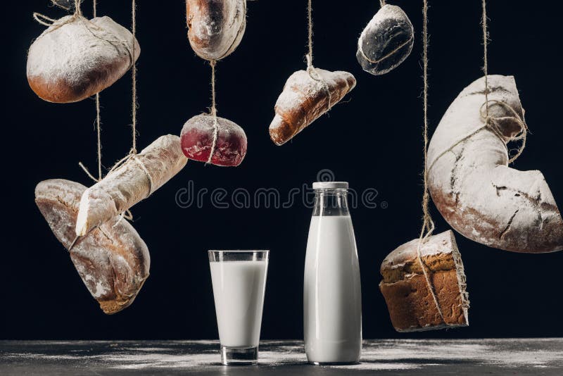 Milk on Table and Bread with Flour Hanging on Strings Isolated on Black ...
