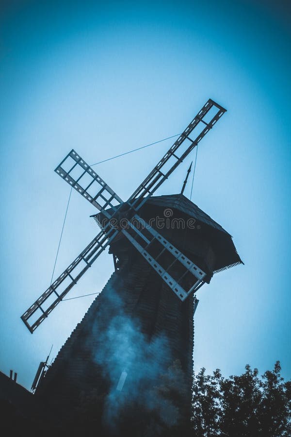 Silhouette of a Blue Mill on a Background of Blue Sky and Plants Stock ...