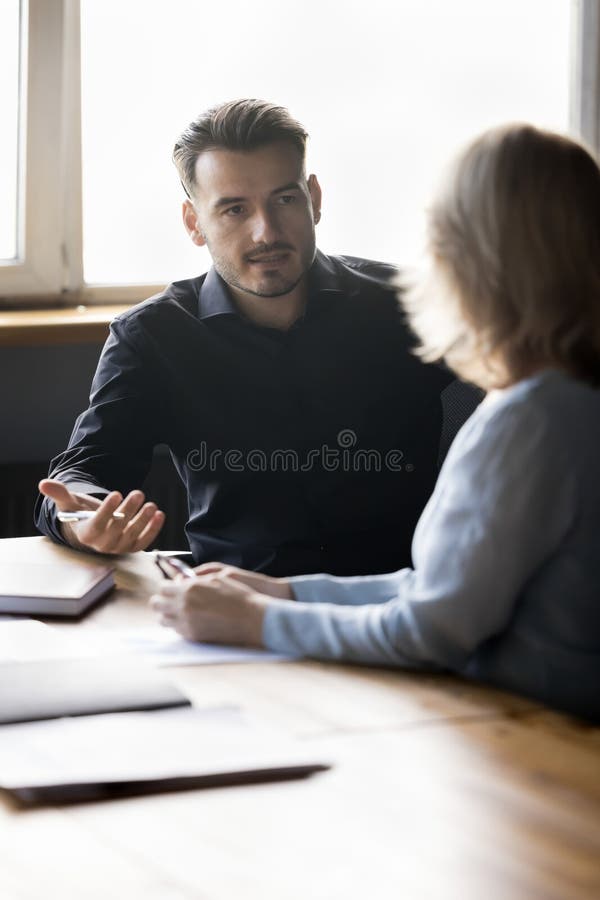 Millennial Business Professional Man Talking To Female Coworker Stock
