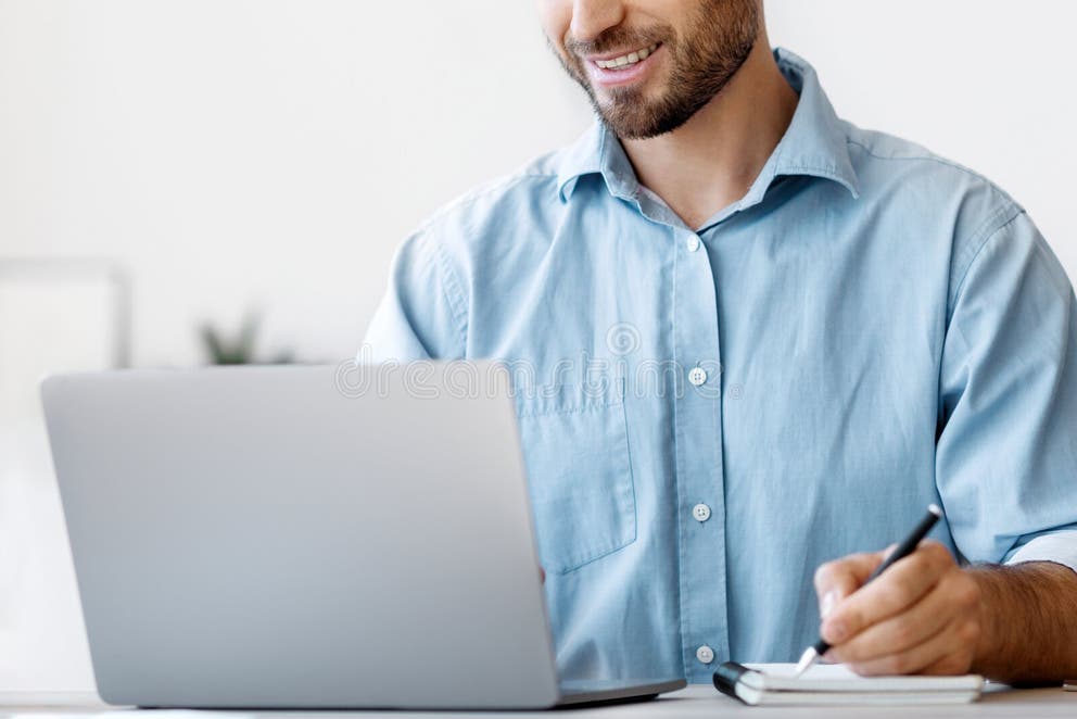 Millennial Male Entrepreneur Using Laptop and Taking Notes at Workplace ...