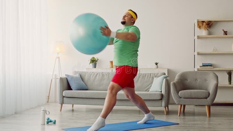 Millennial Man Exercising with a Stability Ball in a Modern Home ...