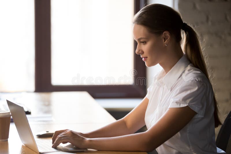 Millennial Office Worker Female Sitting at Desk Typing on Computer ...