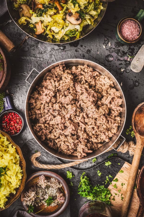 Minced Meat in Cooking Pot on Rustic Kitchen Table with Ingredients ...
