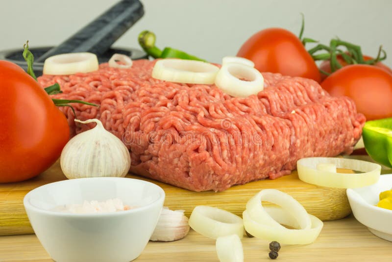 Minced Meat on Cutting Board and Vegetables on Wooden Background Stock ...