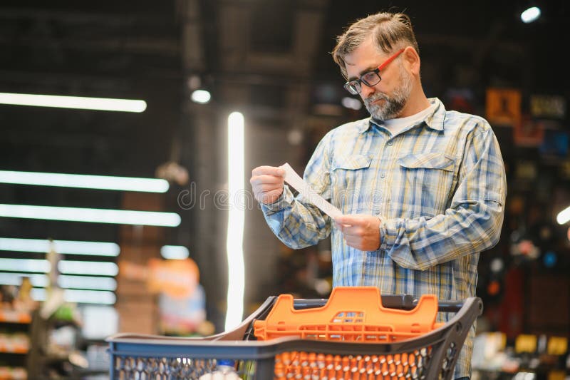Minded Man Viewing Receipts in Supermarket and Tracking Prices Stock ...