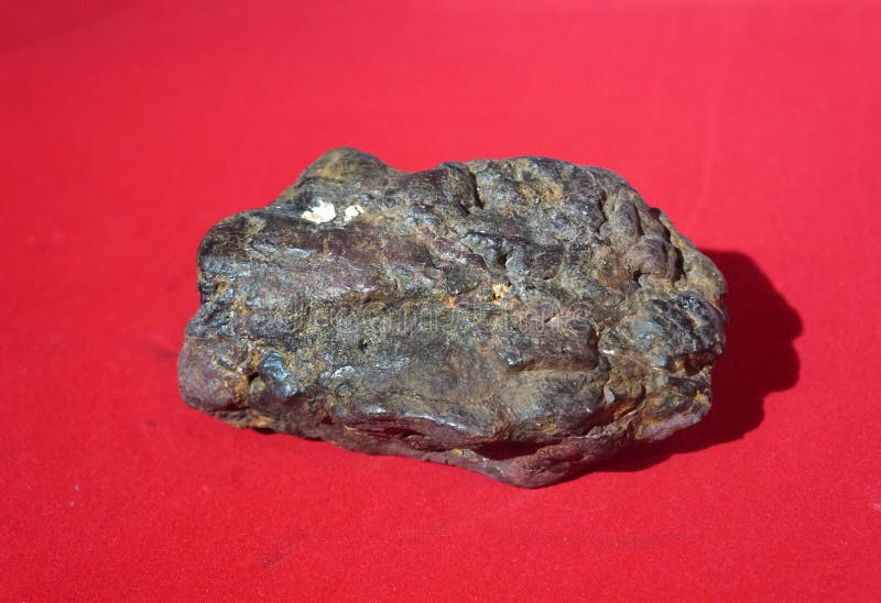 Raw Hematite Mineral Stone on a Red Background in the Museum. Stock ...