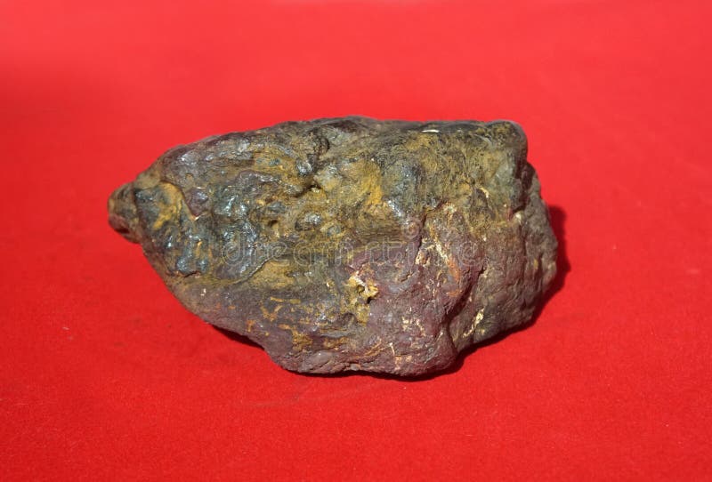 Raw Hematite Mineral Stone on a Red Background in the Museum. Stock ...