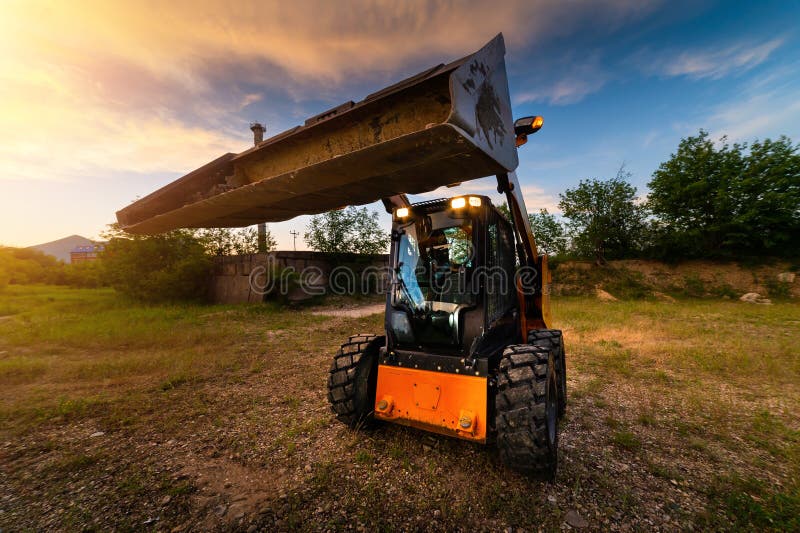 Mini Bulldozer, Small Excavator Against the Backdrop of the Sunset Sky ...