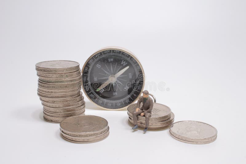 A Mini Business Figure with the Pile Coins and Compass Stock Photo ...