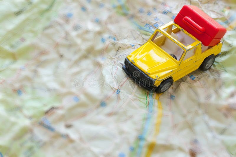 Mini Car and a Red Plastic Suitcase on a Map. Closeup Stock Photo ...