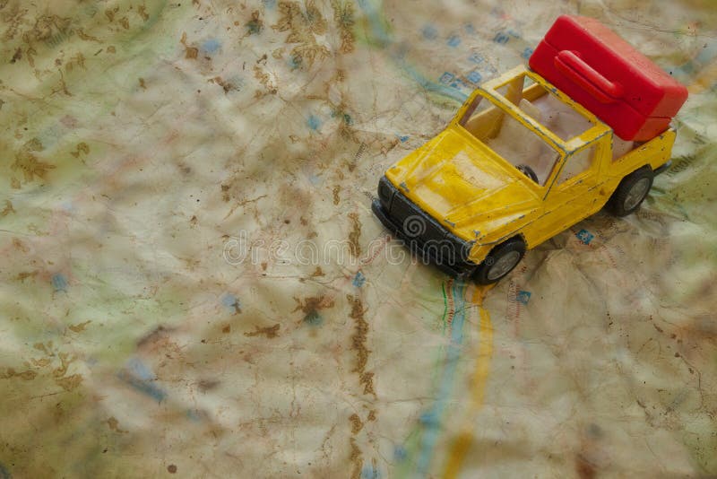 Mini Car and a Red Plastic Suitcase on a Map. Closeup Stock Photo ...
