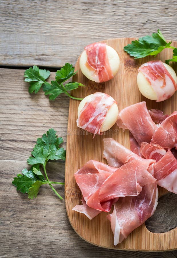 Mini Cheese and Prosciutto Wraps on the Wooden Board Stock Image ...