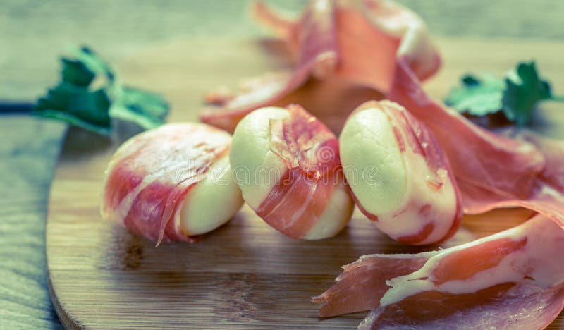 Mini Cheese and Prosciutto Wraps on the Wooden Board Stock Image ...