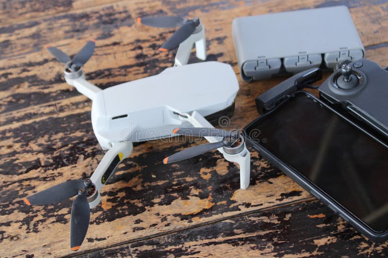 A Mini Drone, Battery and Remote Control on a Wooden Floor Stock Photo ...