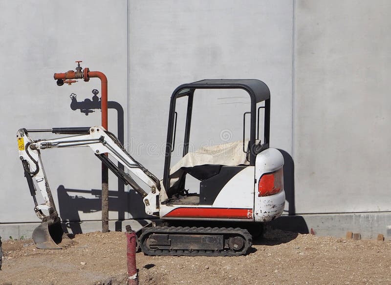 Digger, Mini Excavator and Dozer in a Road Construction Site. Pipes ...
