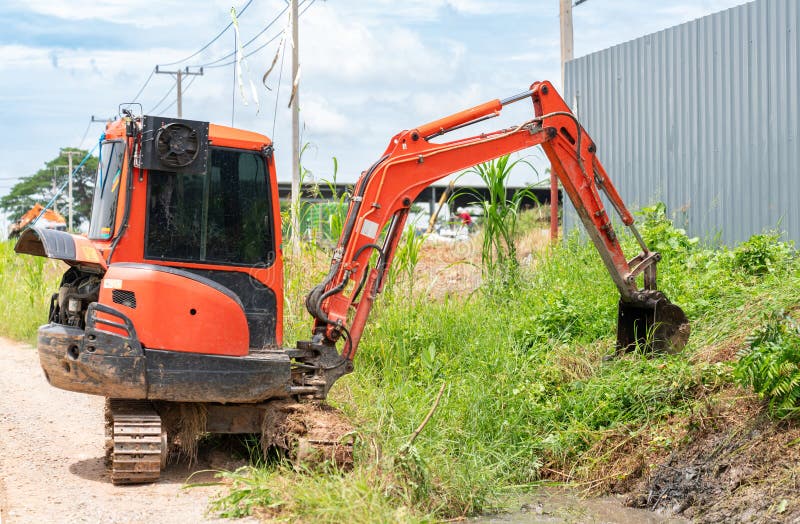 Mini Excavator Dig Drainage Canal Anc Clear Grass on a Construction ...
