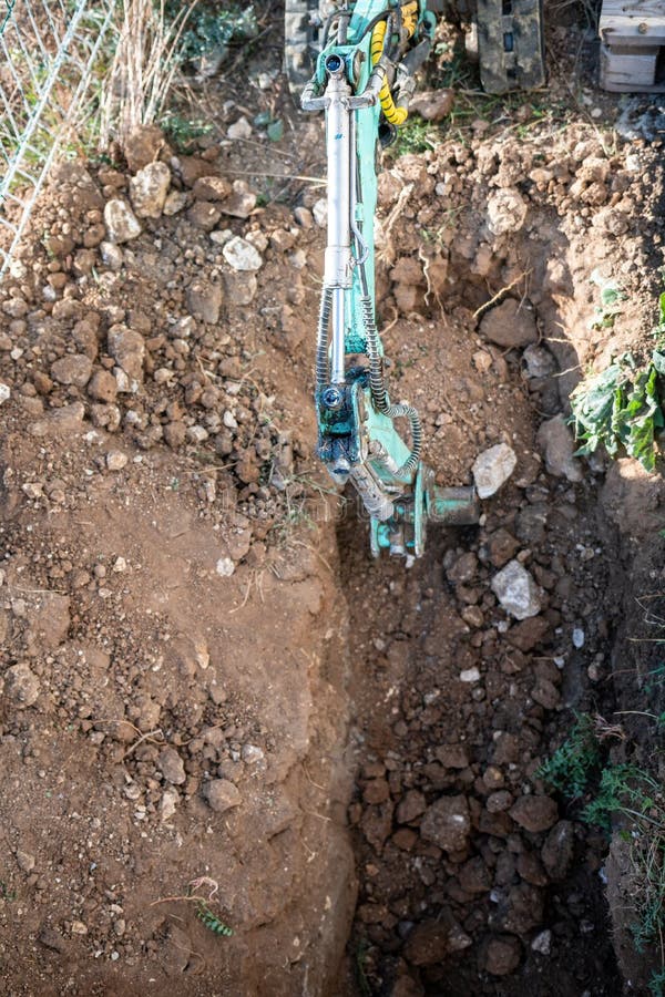 Mini Excavator Digs a Trench To Lay Pipes. Close Up of an Excavator ...