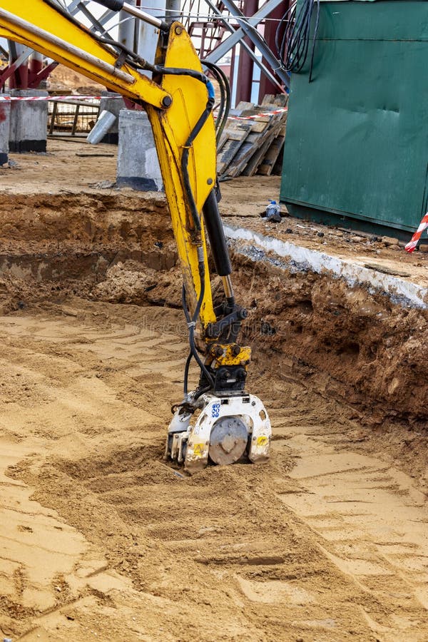 A Mini Excavator Rams the Ground with a Vibrating Plate. Laying of ...