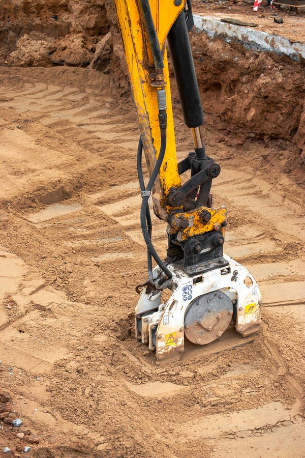 A Mini Excavator Rams the Ground with a Vibrating Plate. Laying of ...