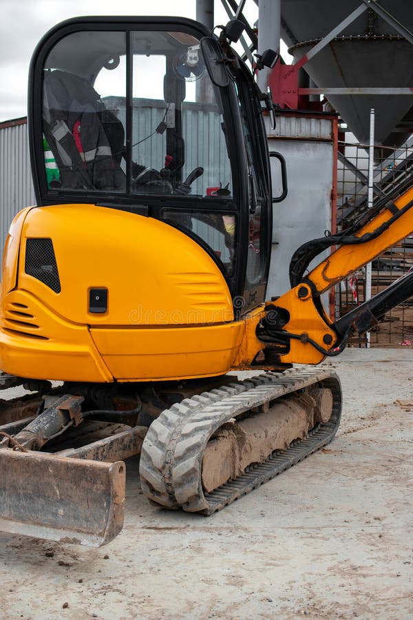 A Mini Excavator Rams the Ground with a Vibrating Plate. Laying of ...