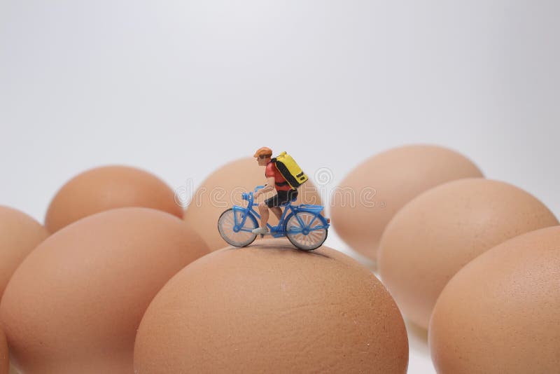 A Mini Figure Ride the Bike on the Eggs Stock Photo - Image of safety ...