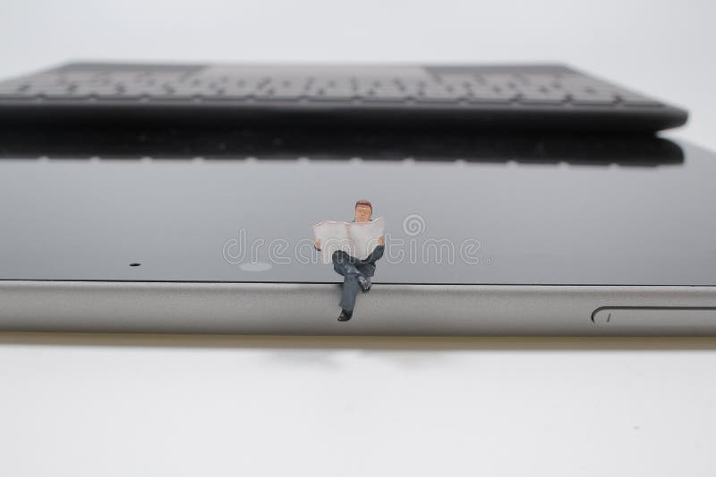 A Mini Figure Sitting on a Laptop while Working on a Laptop and Another ...
