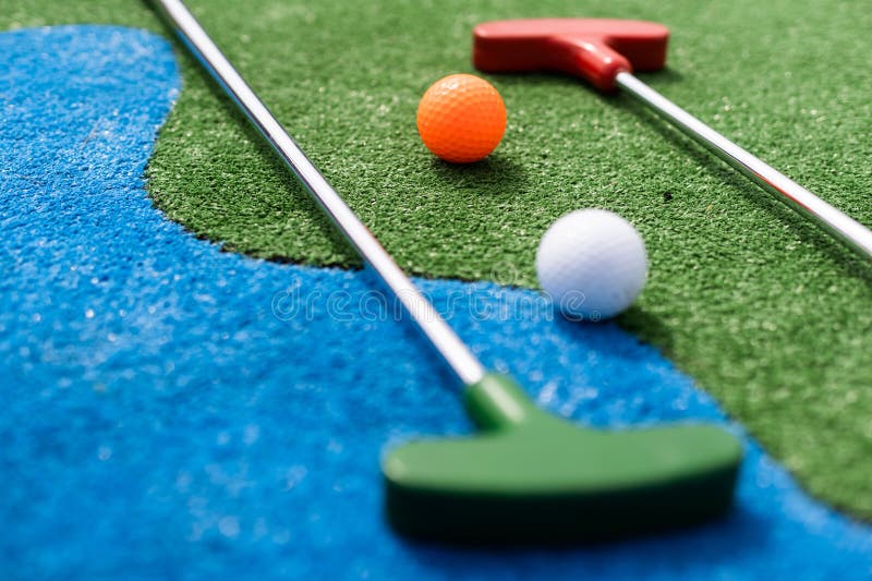Mini-golf Clubs and Balls of Different Colors Laid on Artificial Grass ... Mini-golf Clubs and Balls of Different Colors Laid on Artificial Grass ...