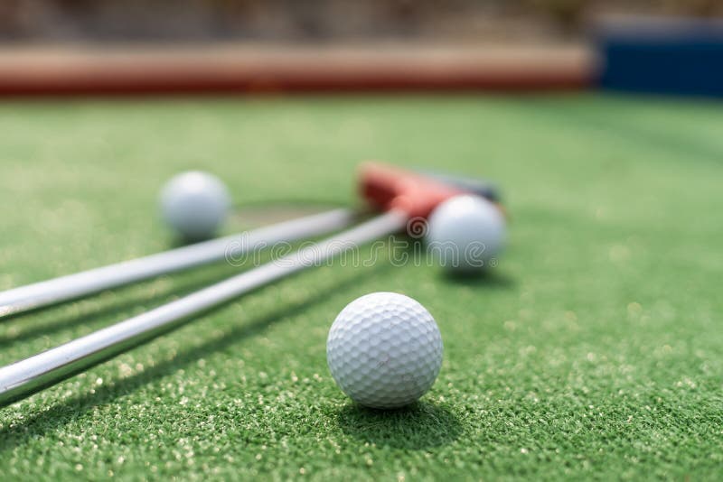 Mini-golf Clubs and Balls of Different Colors Laid on Artificial Grass ... Mini-golf Clubs and Balls of Different Colors Laid on Artificial Grass ...